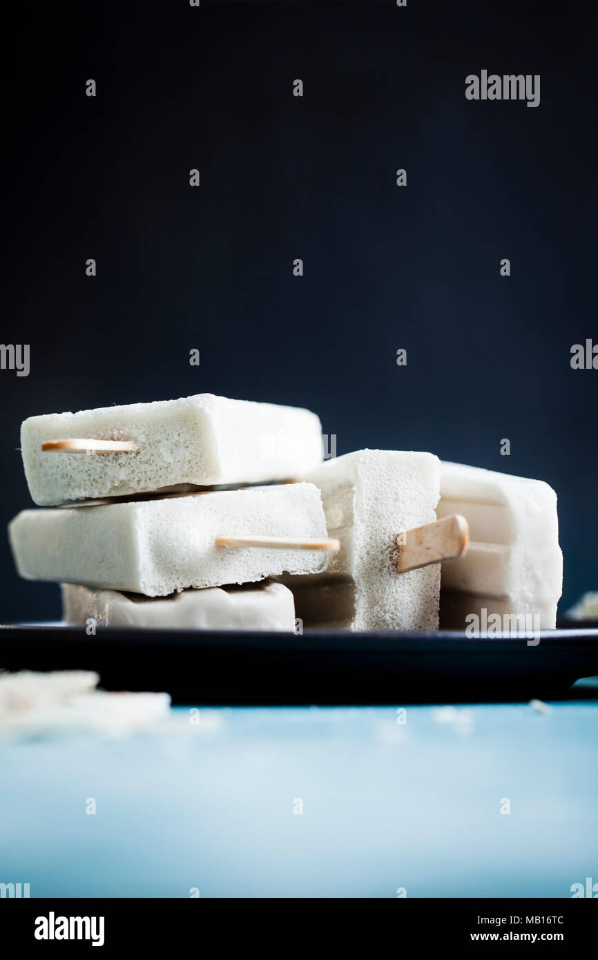 Popsicle sticks on plate with dark background Stock Photo - Alamy