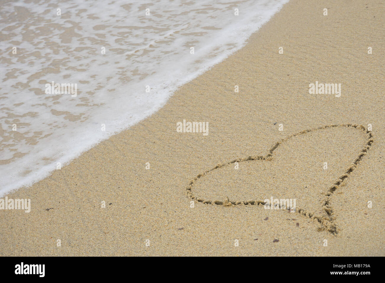 Heart shape drawn in sand on beach with sea wave Stock Photo - Alamy