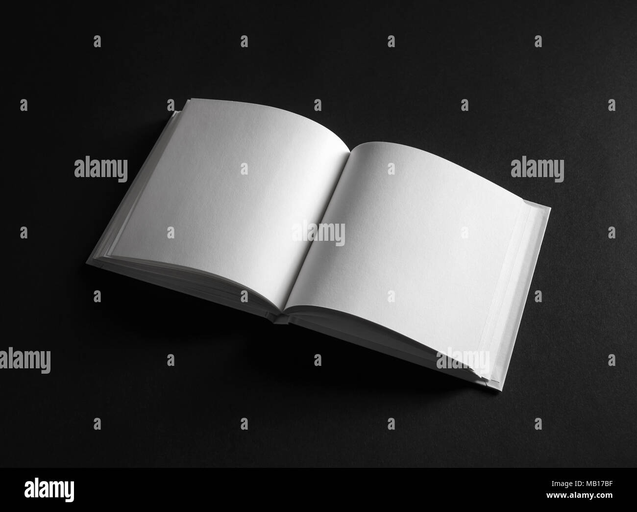Open blank square book on black paper background Stock Photo - Alamy