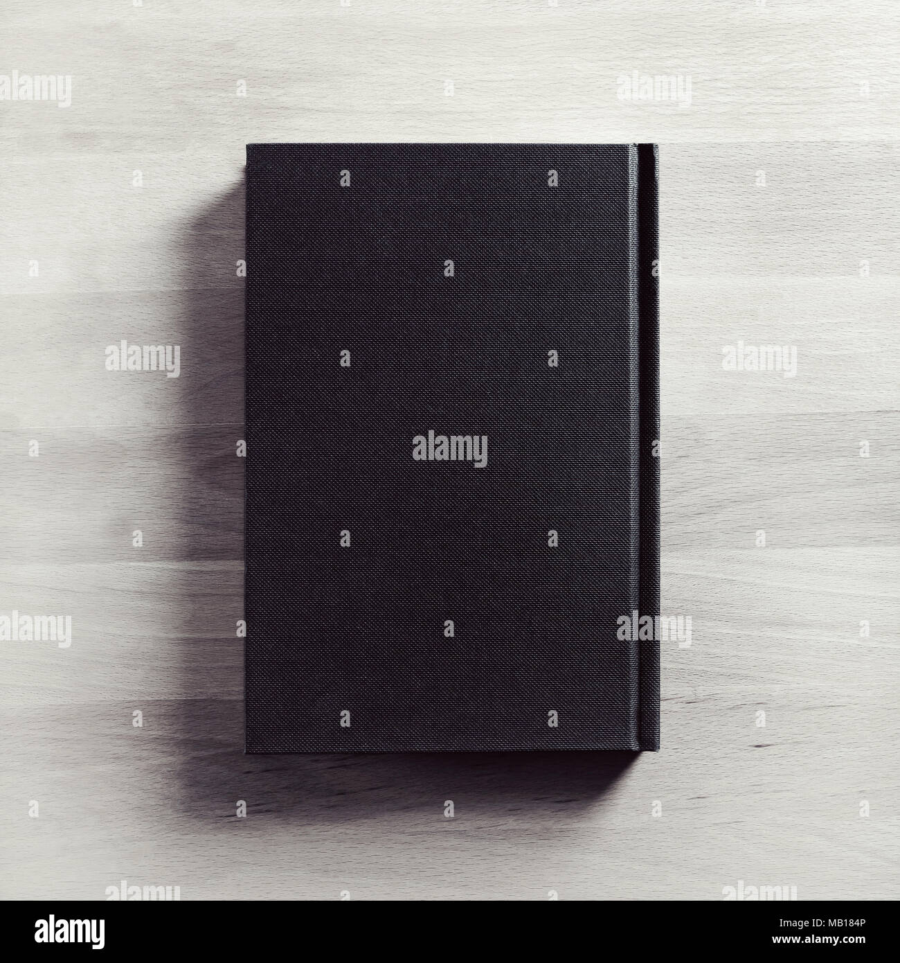 Blank black cover book on wood table background. Template for placing ...