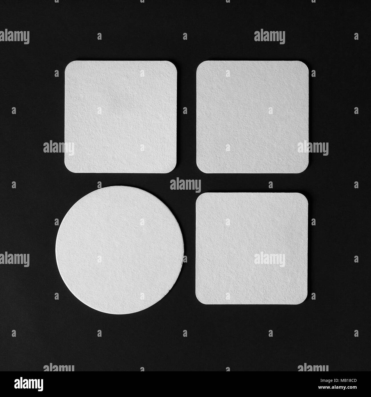 Four blank beer coasters on black paper background. Top view. Flat lay ...