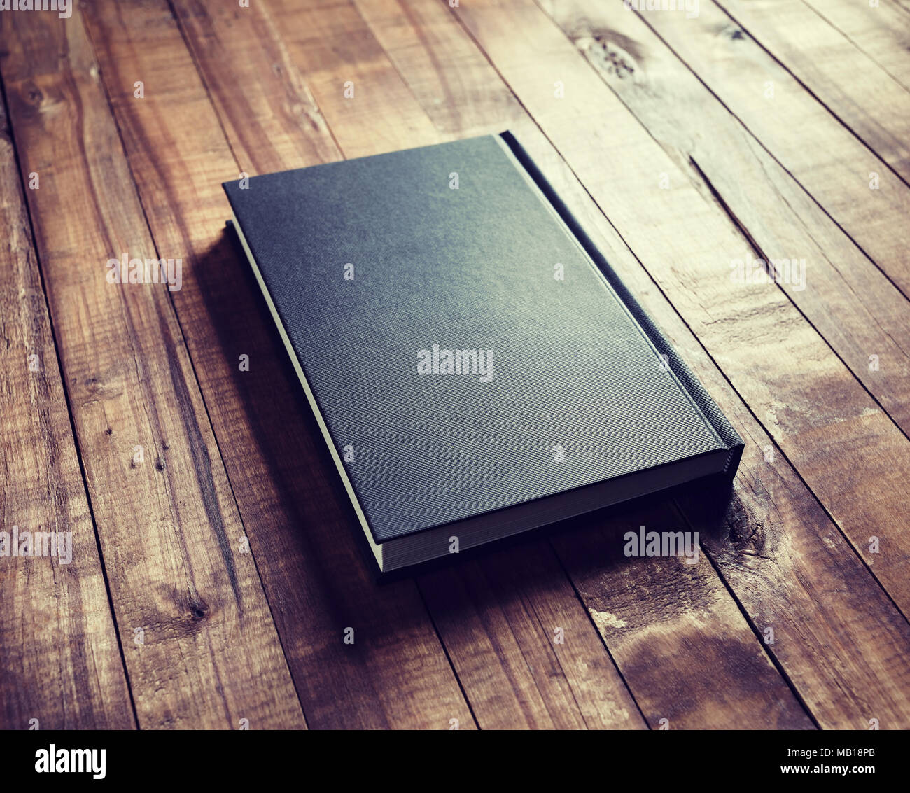 Blank black book cover on vintage wood table background. Vintage toned ...