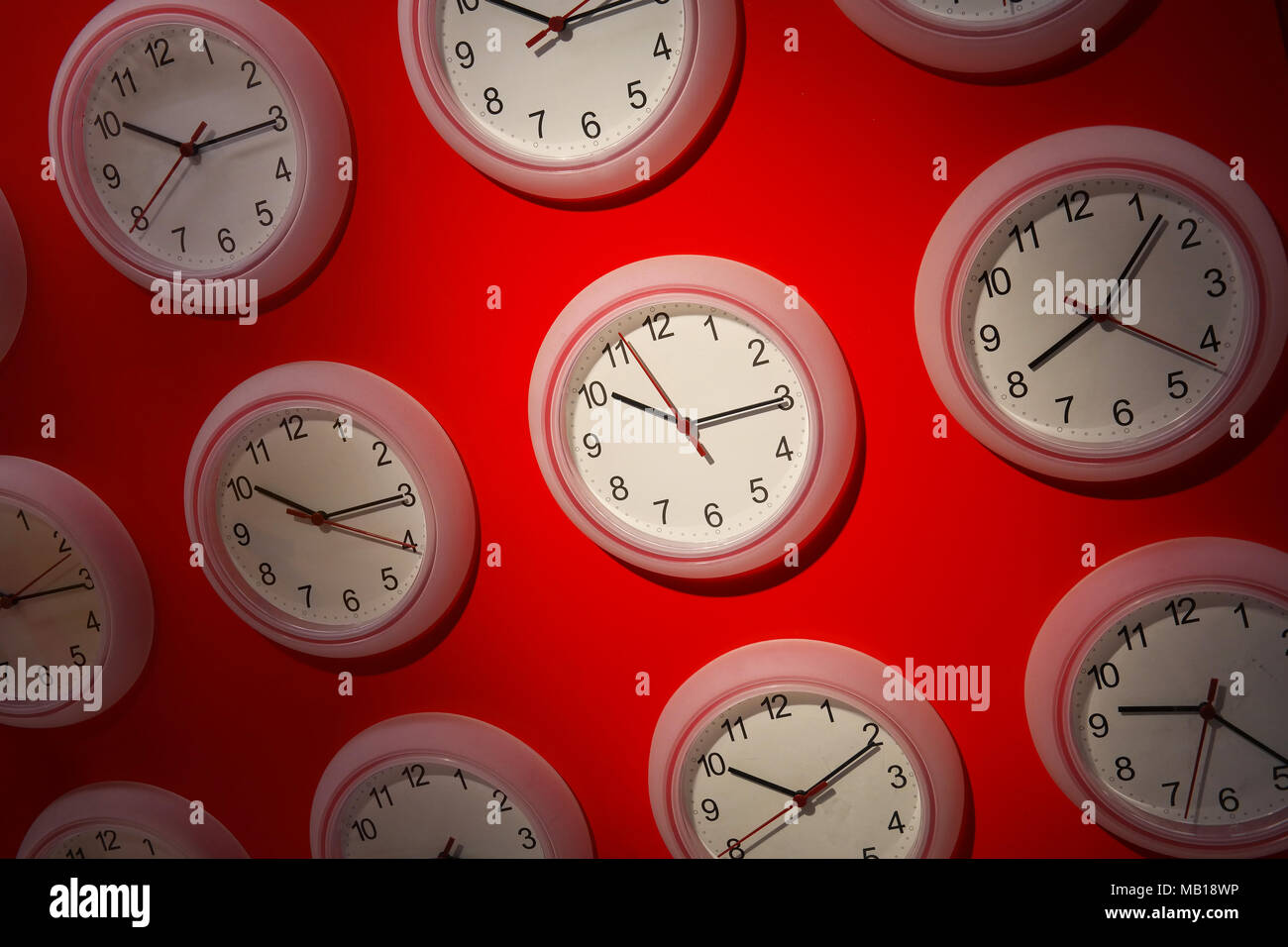 Clocks on a red background Stock Photo - Alamy