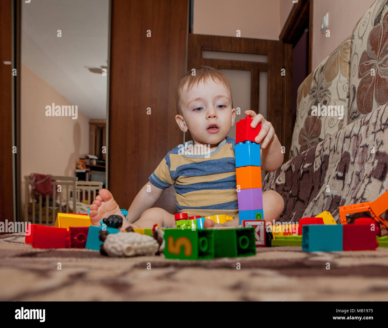 Sweet little boy building tower from cubes at home Stock Photo - Alamy