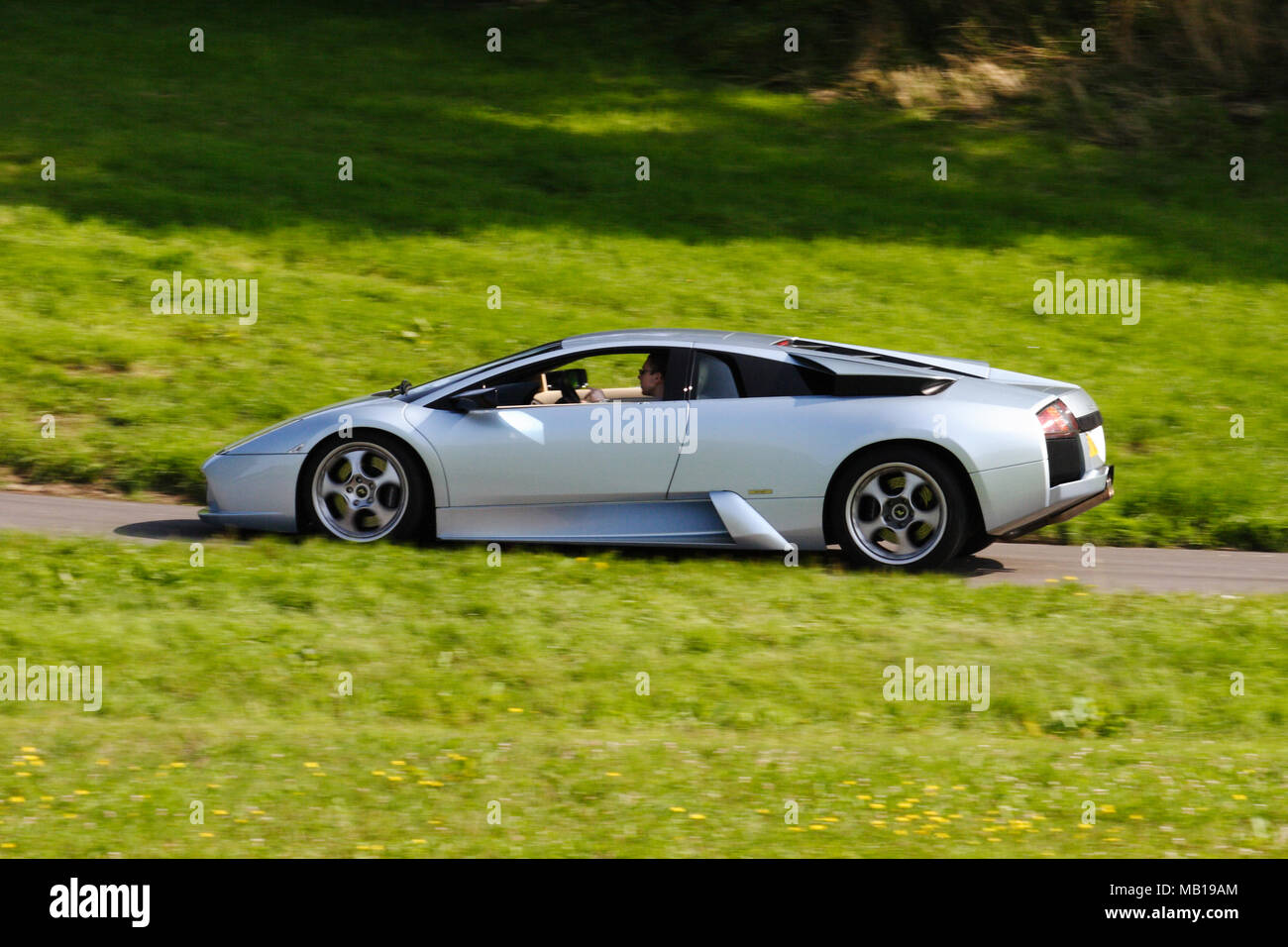Silver Lamborghini Murcielago driving fast on a country road Stock ...