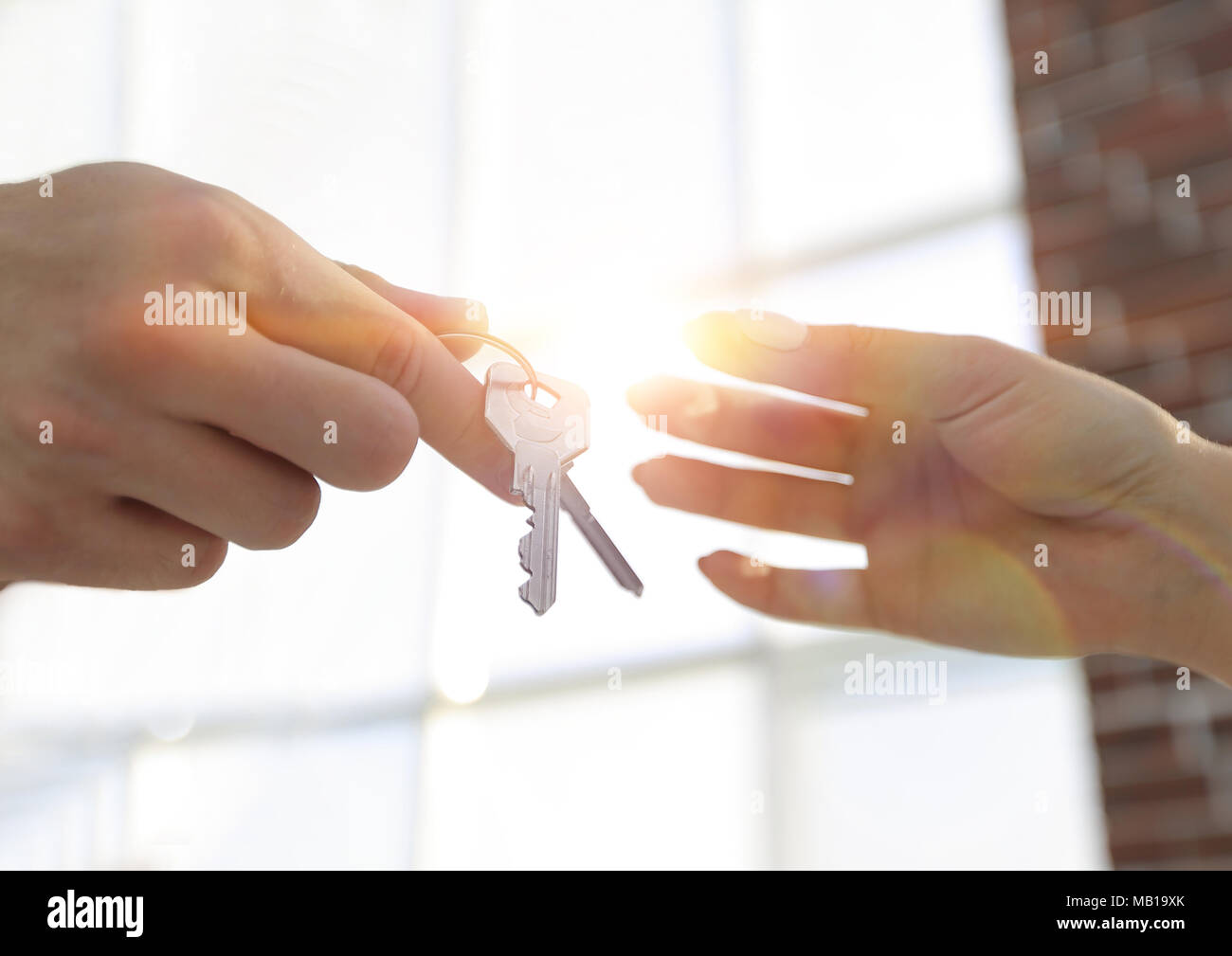 Female hand giving keys from new apartment to male hand on blurred ...
