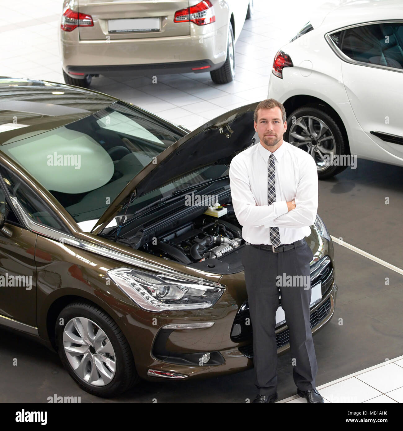 successful businessman in a car dealership - sale of vehicles to ...