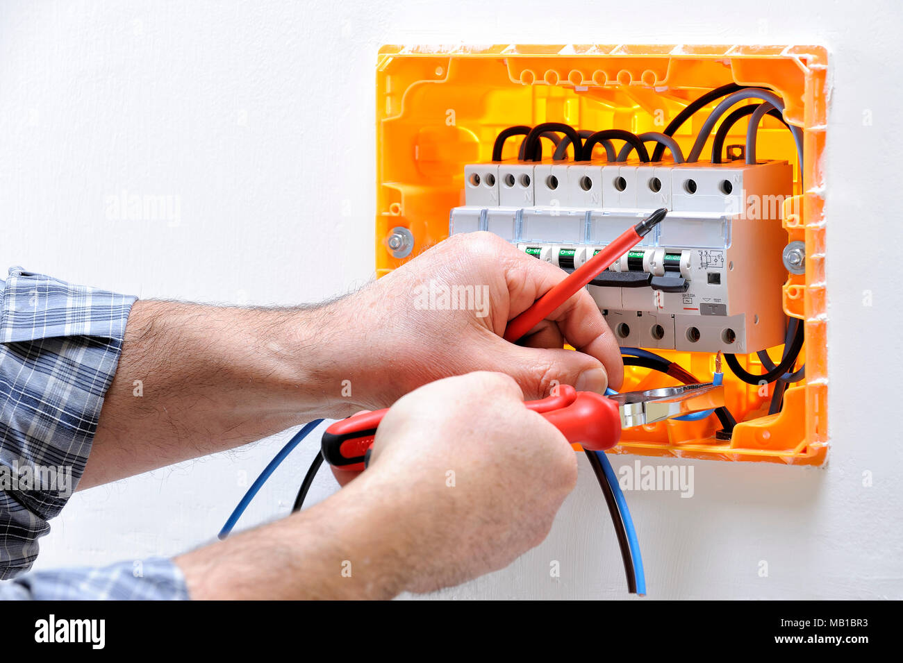 Electrician technician working on a residential electric panel, he ...