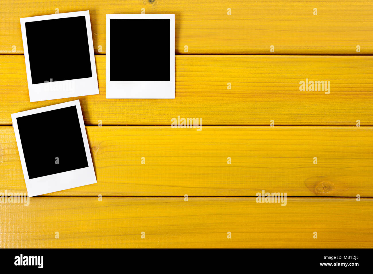 Three blank photo prints on a wood desk or table. Space for copy. Paths ...