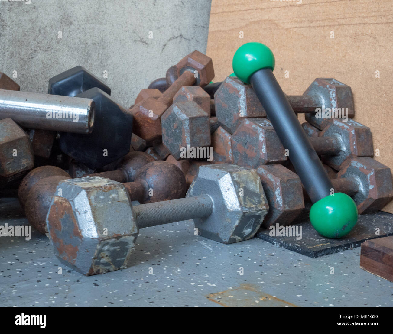 Messy pile of dumbbells in a gym corner on the floor Stock Photo - Alamy