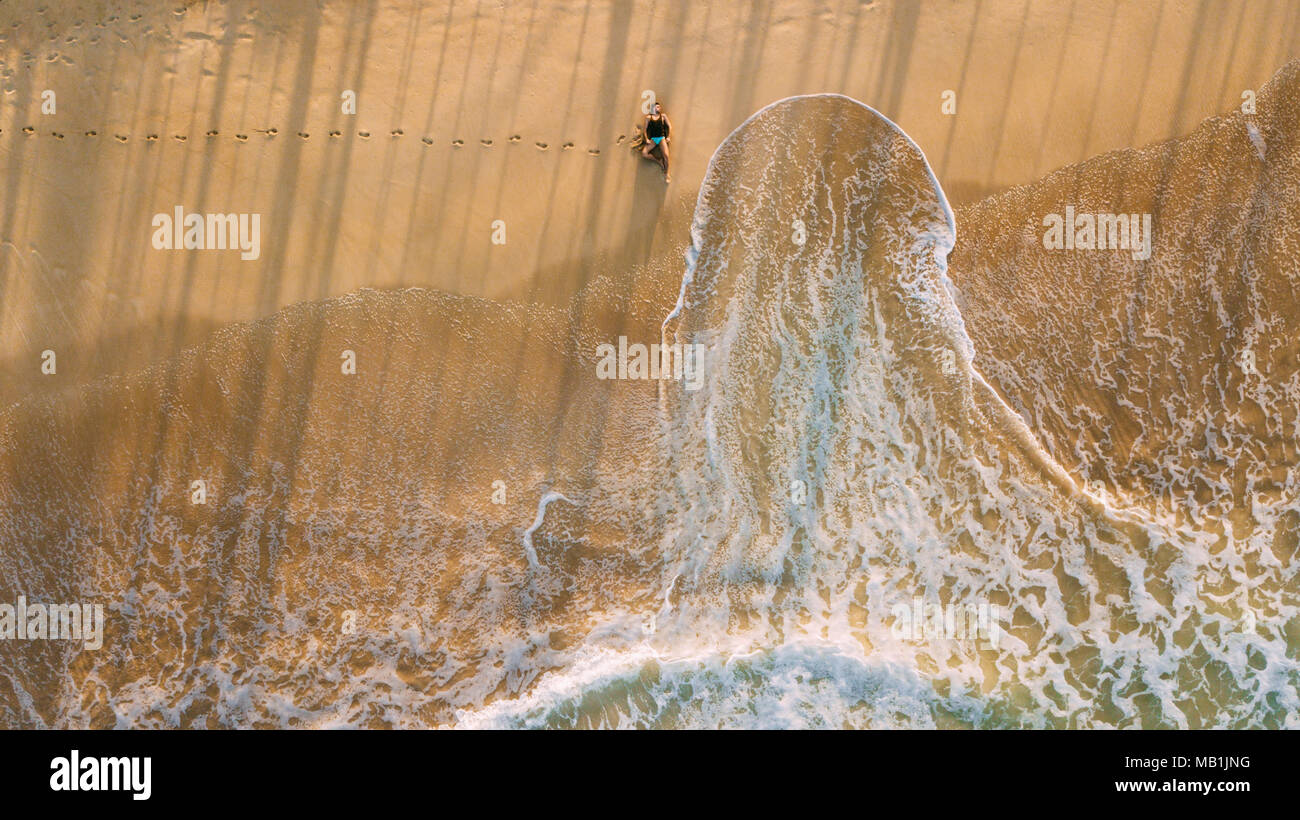 one men lies on the beach. Wave and shadow reflection from palms. Wave ...