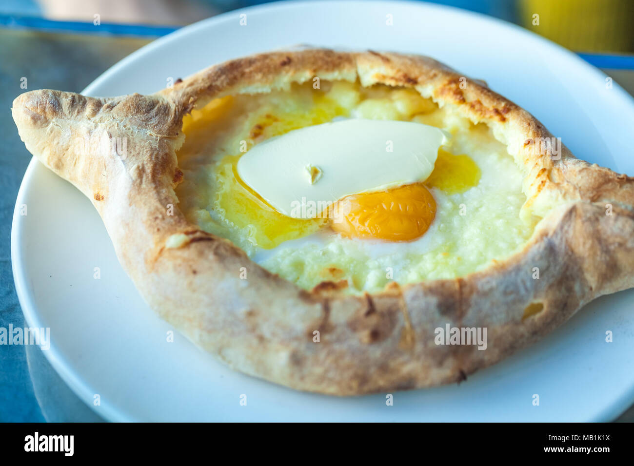Adjarian khachapuri with eggs on the table. Traditional Georgian ...