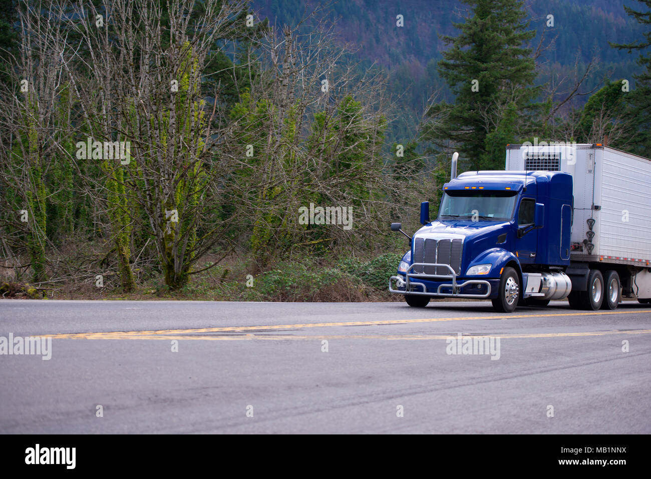 Dark blue American bonnet day cab big rig semi truck with grille guard ...