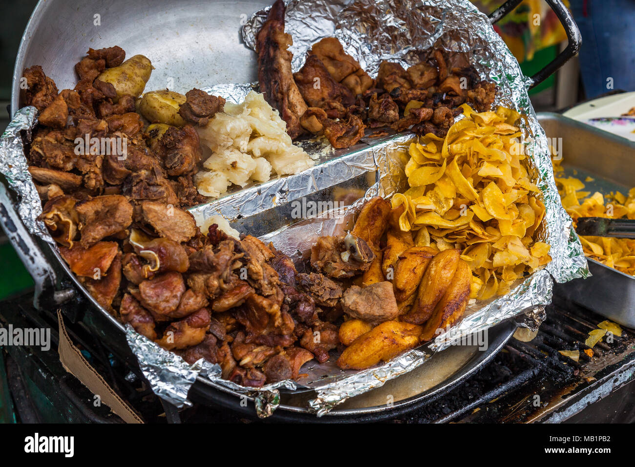 Ecuadorian typical food, fried pork with banana, cassava, corn and ...