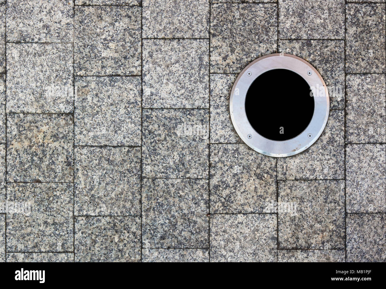 The city pavement is lined with square marble tiles. Round lamp is ...