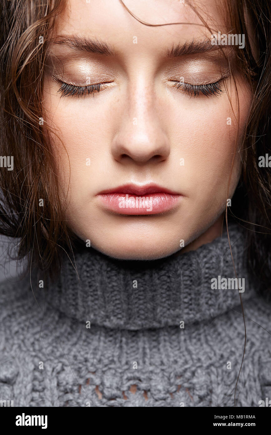 Beauty portrait of young woman in gray wool sweater. Brunette girl with ...