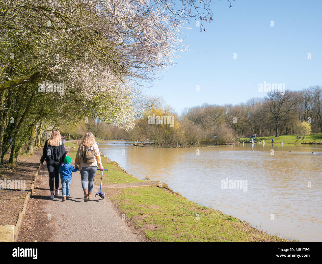 Two women and a child hold hands as they walk along a path next to the ...