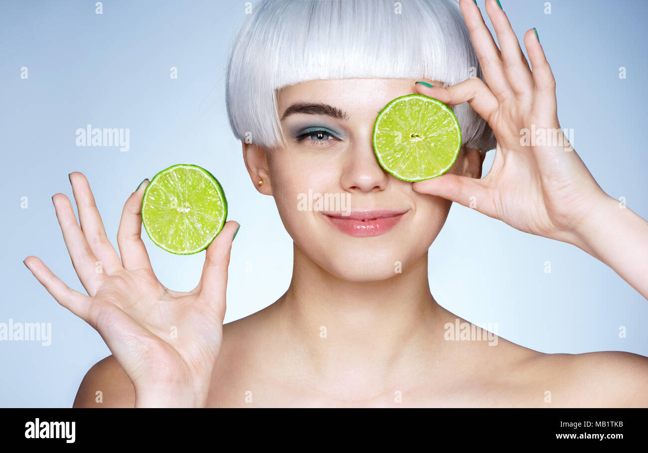 Beautiful smiling girl with halves of green lime. Healthy & Happy Stock ...