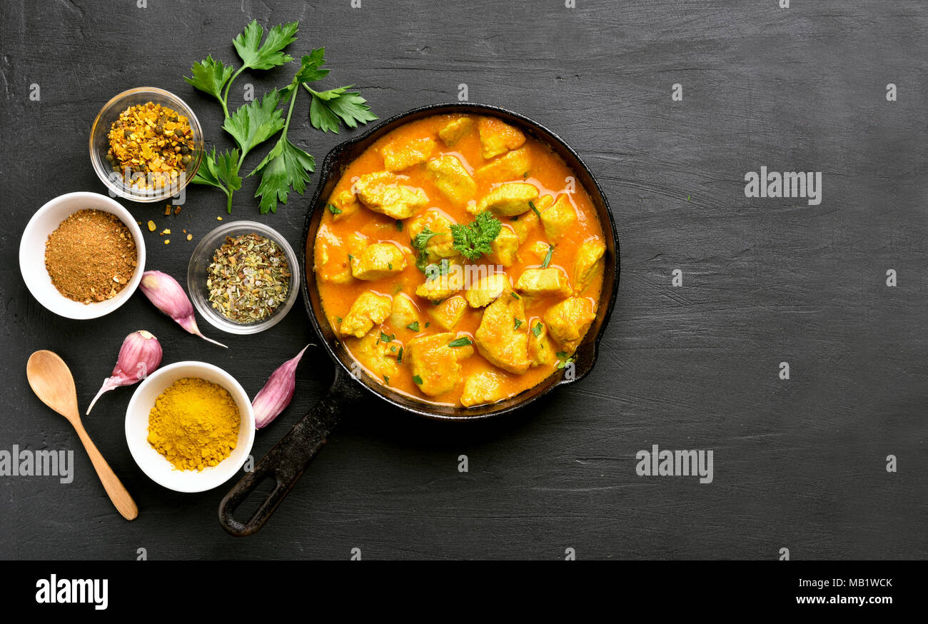 Chicken curry on black stone background with copy space. Top view, flat ...
