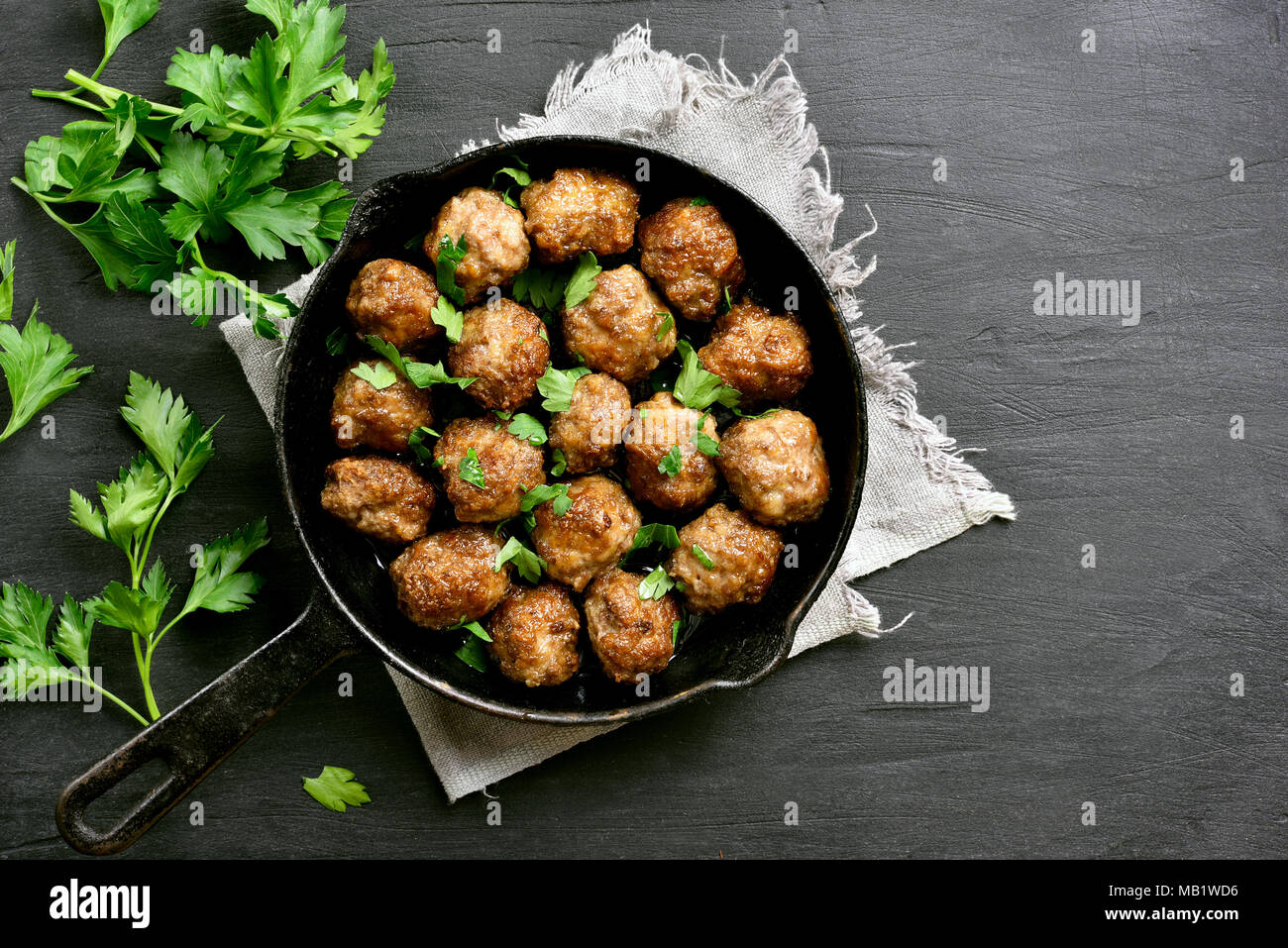 Meatballs in frying pan on black stone background with copy space. Top ...