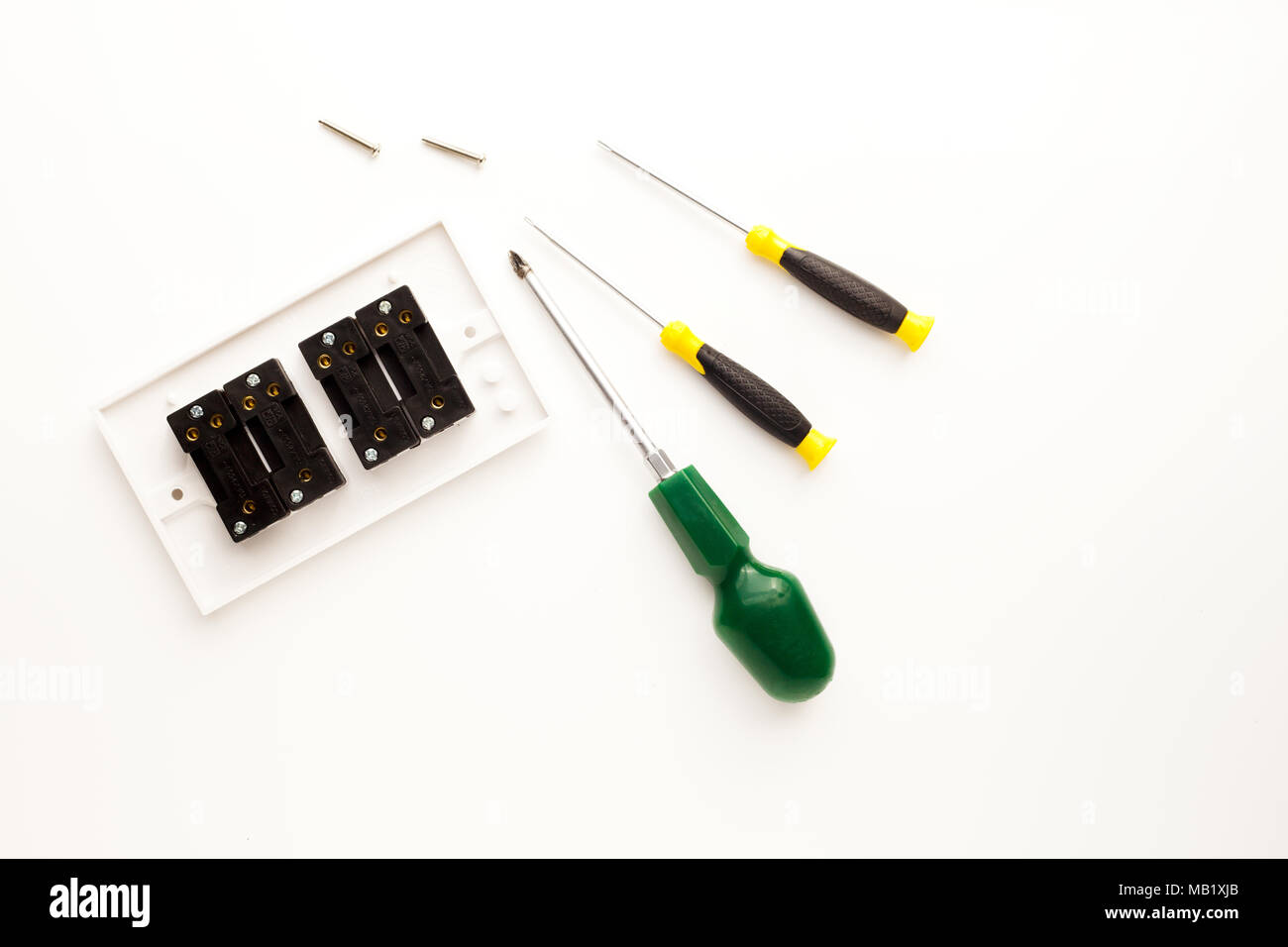 Double socket exposed terminals and various screw drivers on white ...