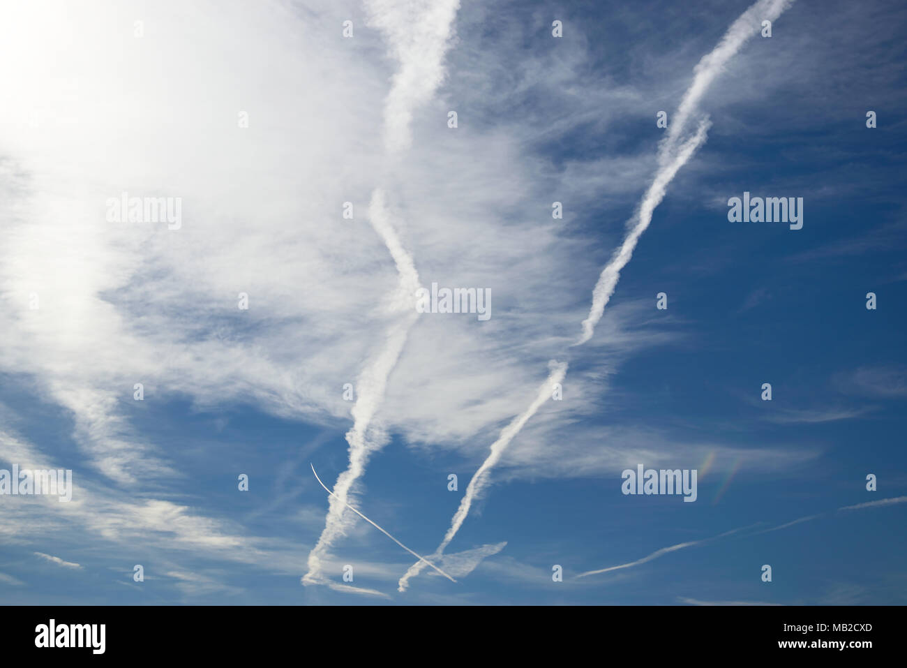 Blue sky with clouds and jet exhaust Stock Photo - Alamy