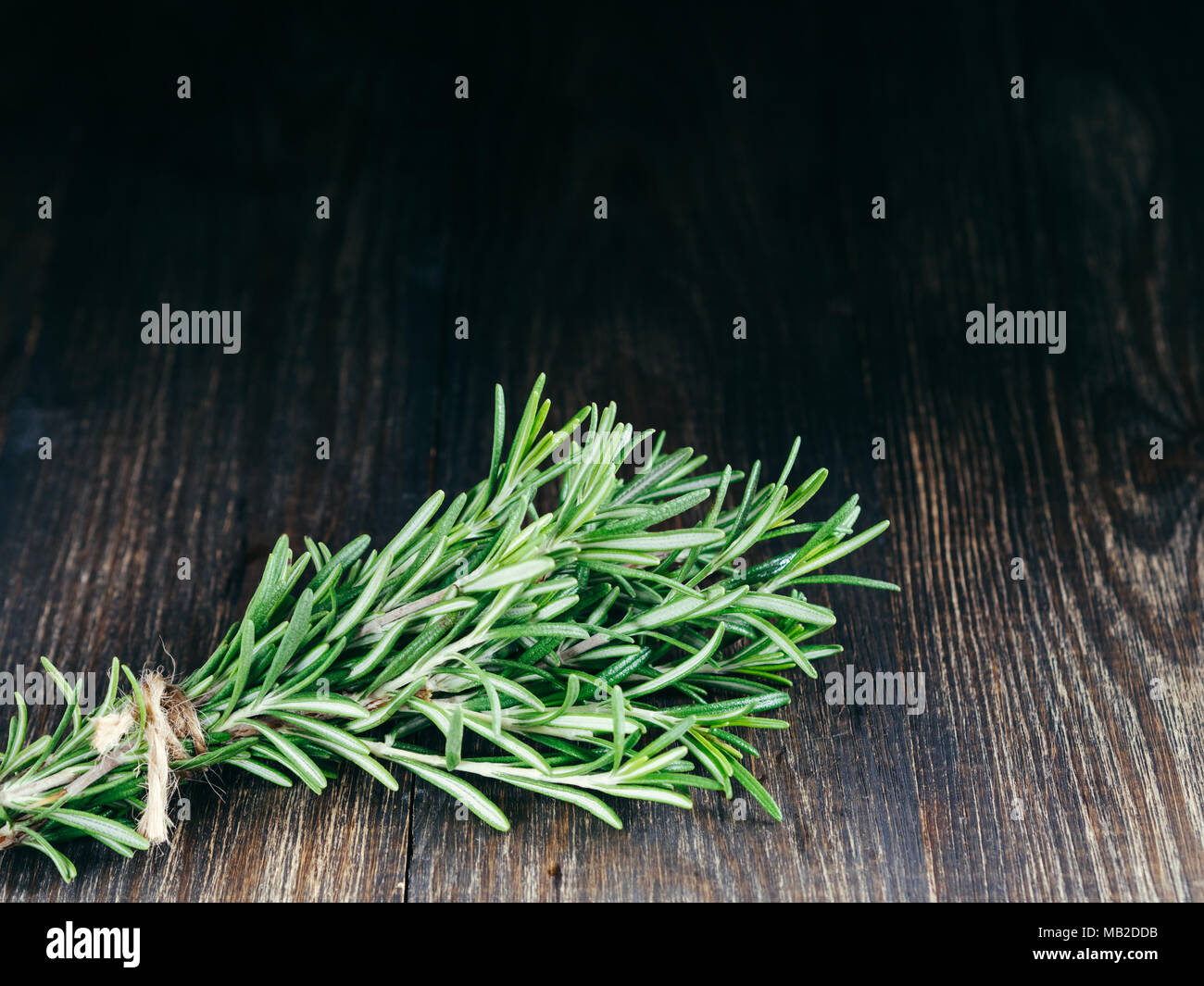 Organic bunch of fresh rosemary on wooden table with copy space. Low ...