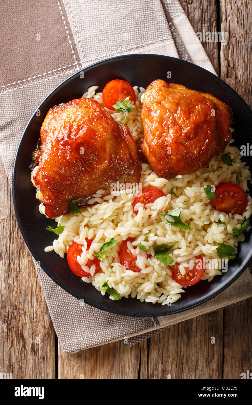 Portion of fried chicken thighs with garnish of rice with vegetables on ...