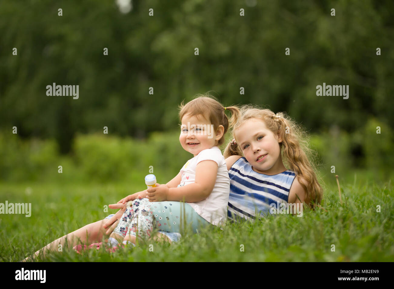 A two babies sisters playing in park, outdoor portrait Stock Photo - Alamy