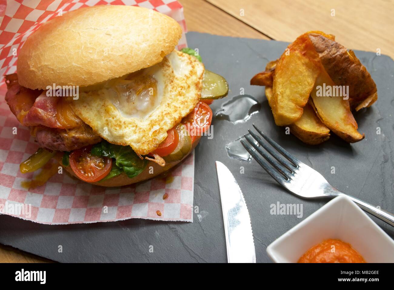 Beef burger with fried egg and chips Stock Photo - Alamy