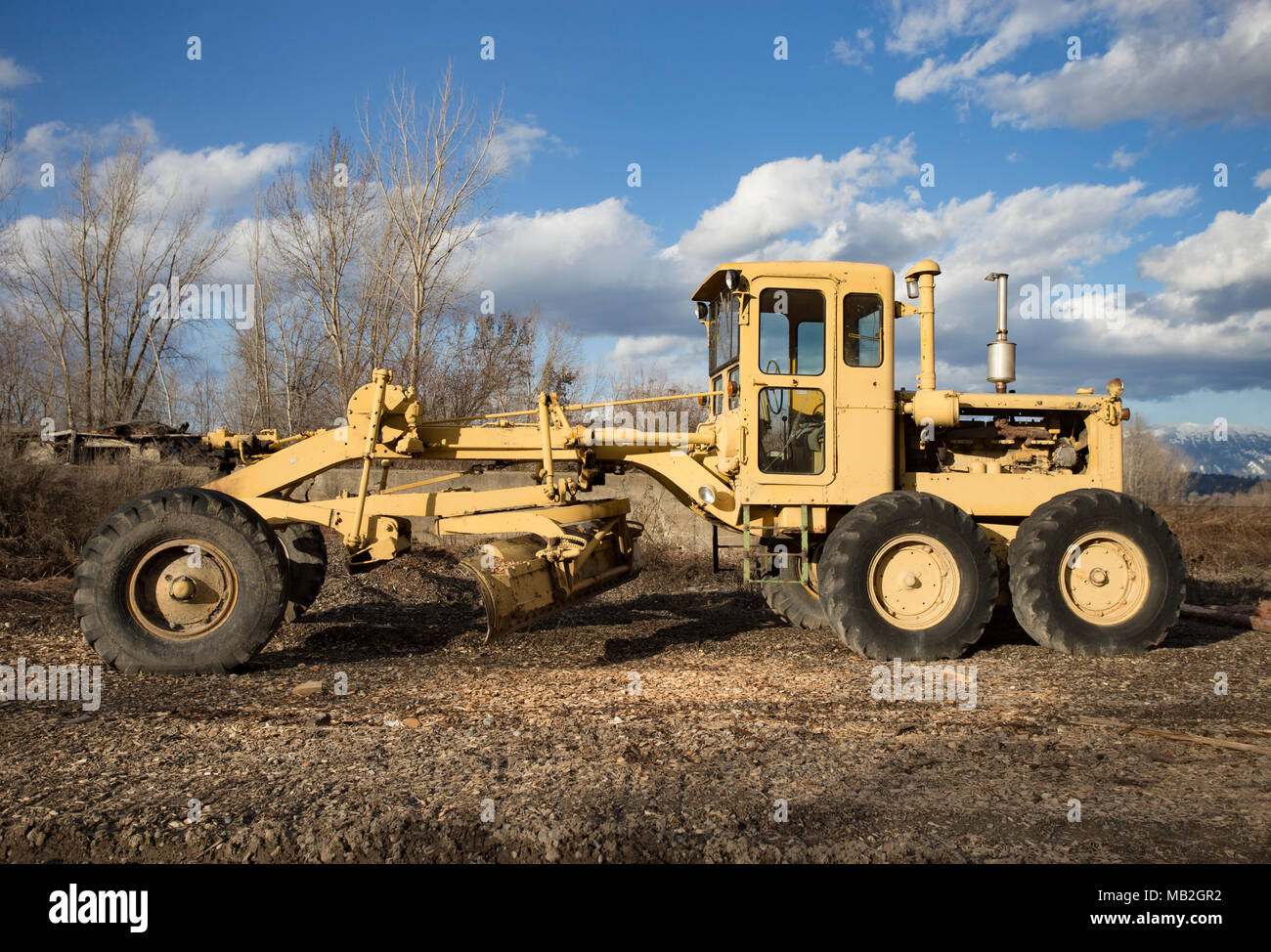 A yellow Caterpillar motor grader, on the yard, at Fodge Pulp Products ...