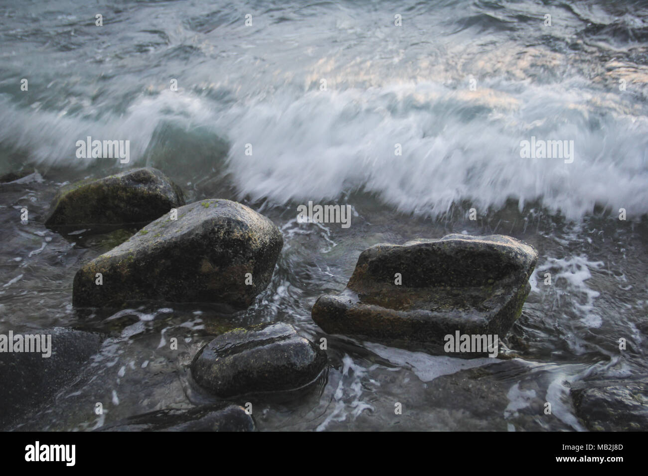 Waves in Lombok Strait hitting rocks Stock Photo - Alamy