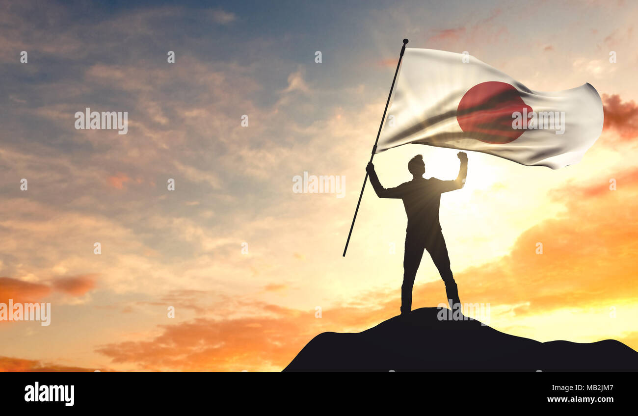 Japan flag being waved by a man celebrating success at the top of a ...