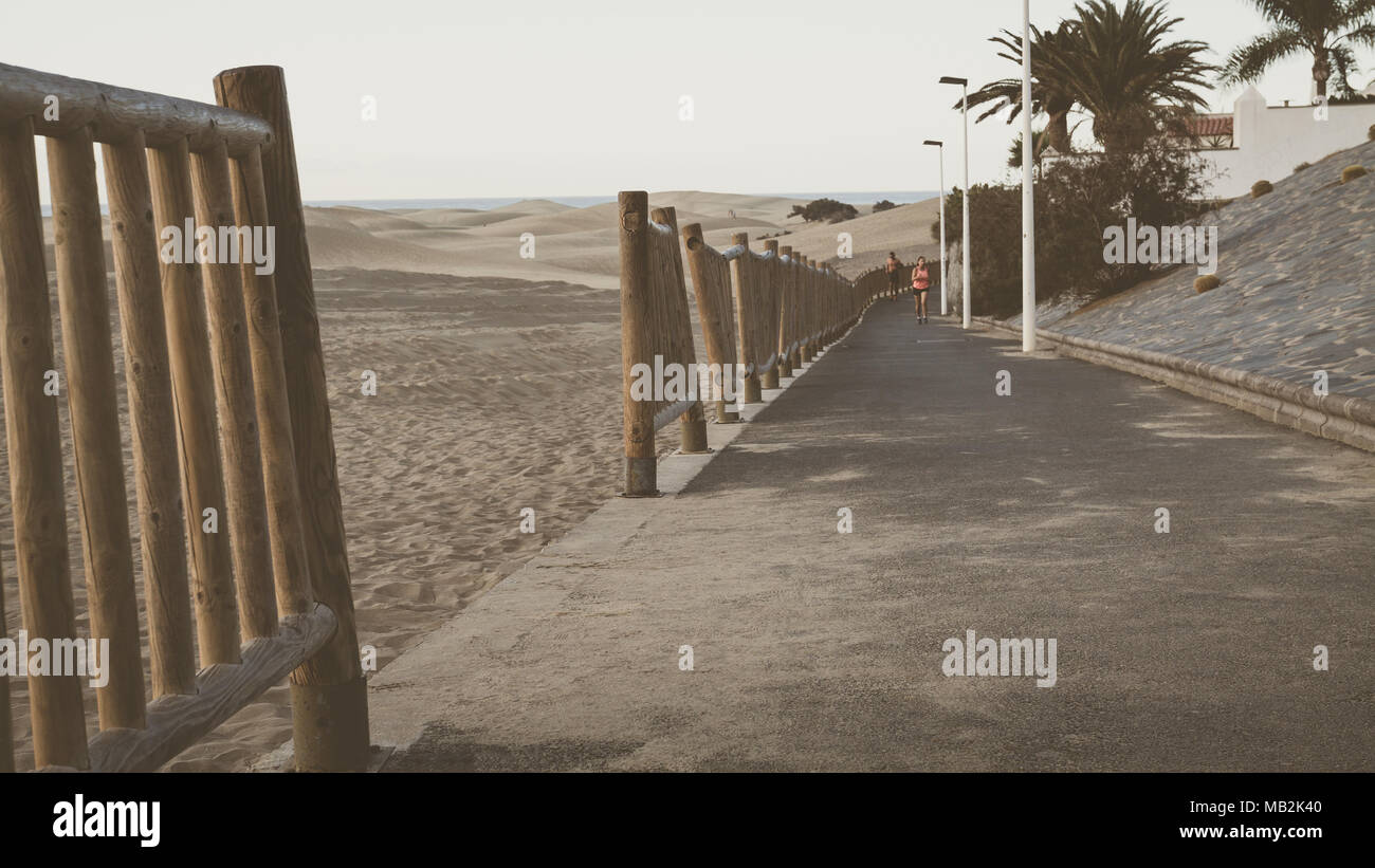 Walkers and runners on seaside promenade in Maspalomas, Gran Canaria ...