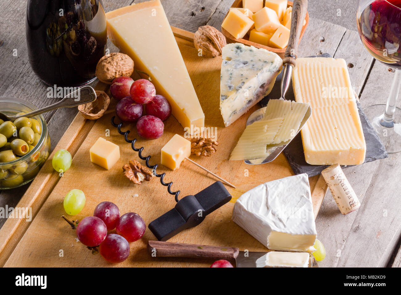 Palette of many types of cheese and some grapes, olives and wine Stock ...