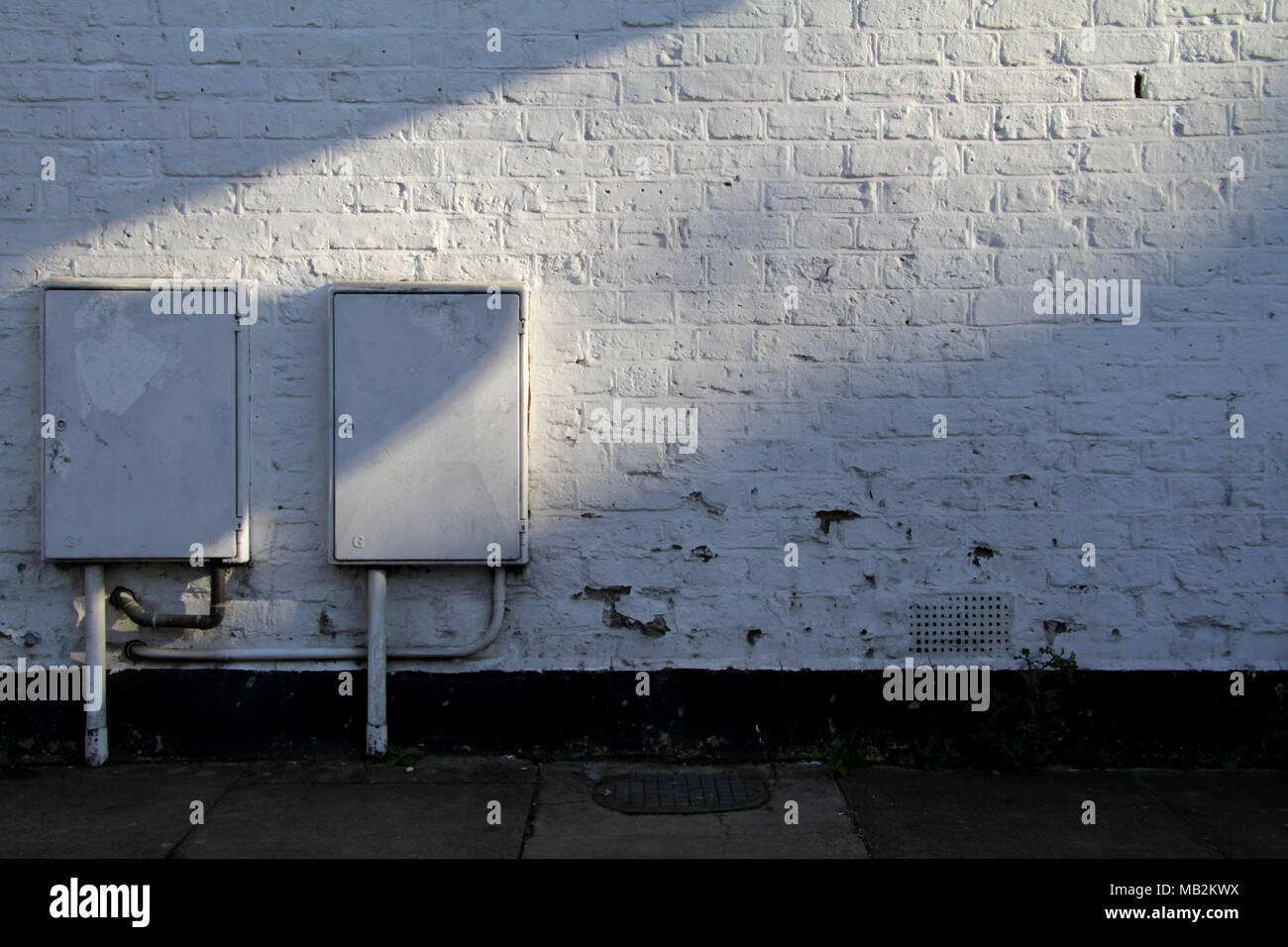 Streetside Electrical Boxes against brickwork wall Stock Photo - Alamy