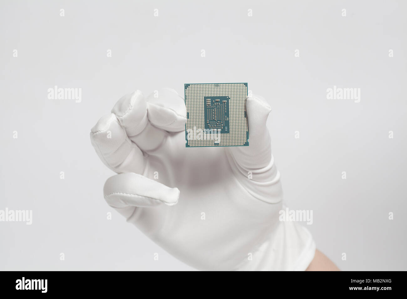 Hand in white glove holding a CPU computer processor microchip isolated ...