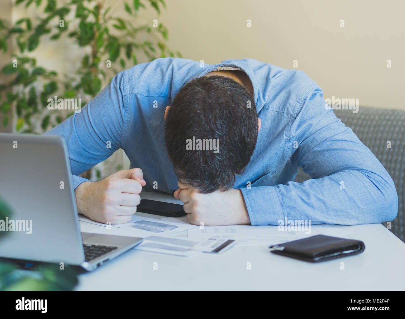 Sad man looking at his monthly bills at home Stock Photo - Alamy