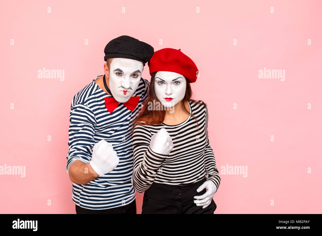 Angry aggressive comedy couple, showing hands ,looking seriously. Clown ...