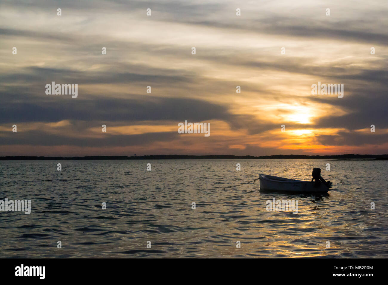 Single boat at sunset, gently rocking in the waters of the sound. Just ...