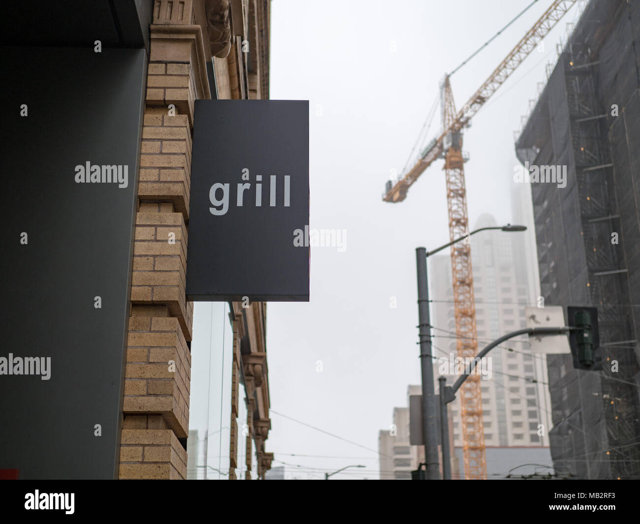 Grill sign displayed outside of restaurant on a foggy, overcast day ...