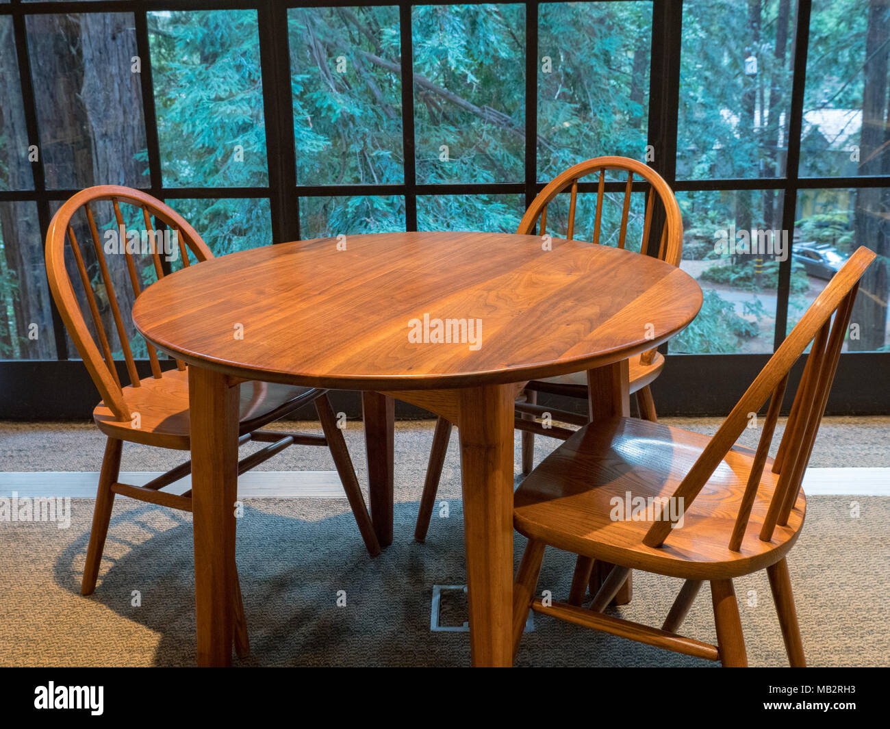 Table in quiet room overlooking forest Stock Photo - Alamy