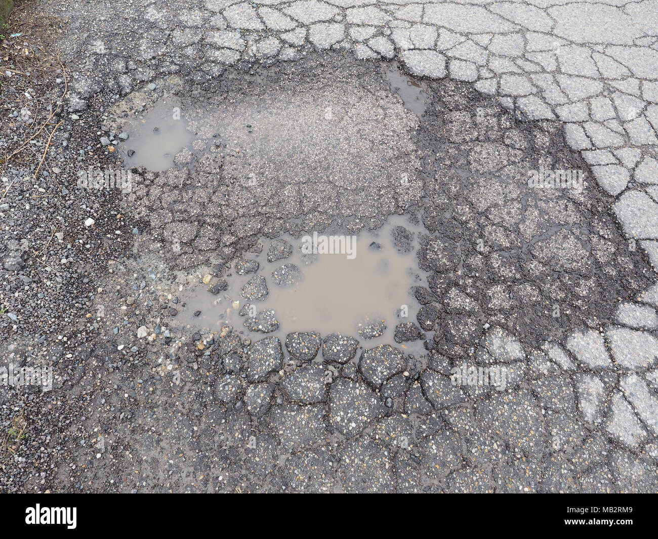 Pothole in a street caused by failure primarily in asphalt pavement ...