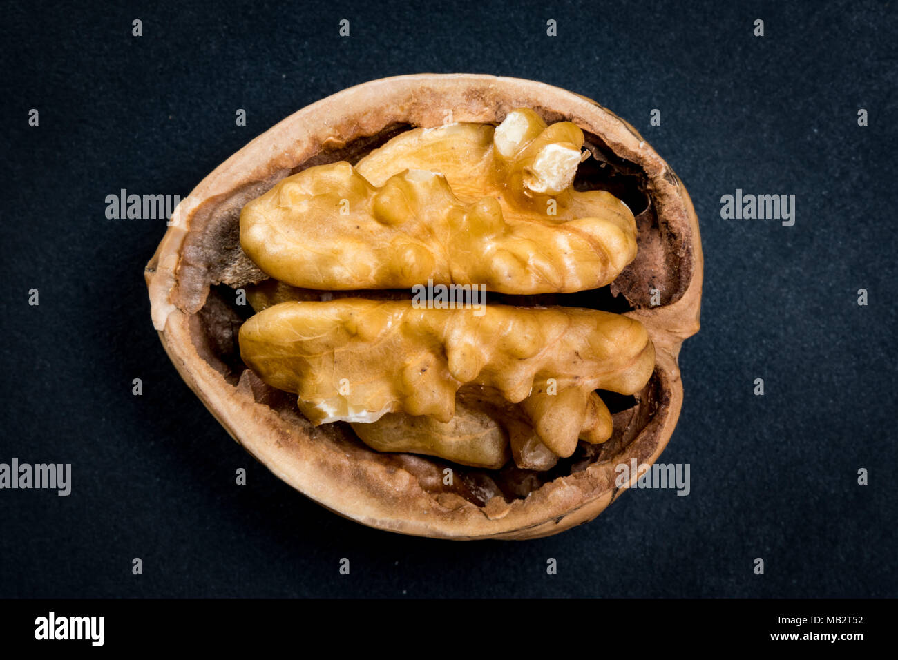 Walnut and Half Shell highlighted against dark background Stock Photo ...