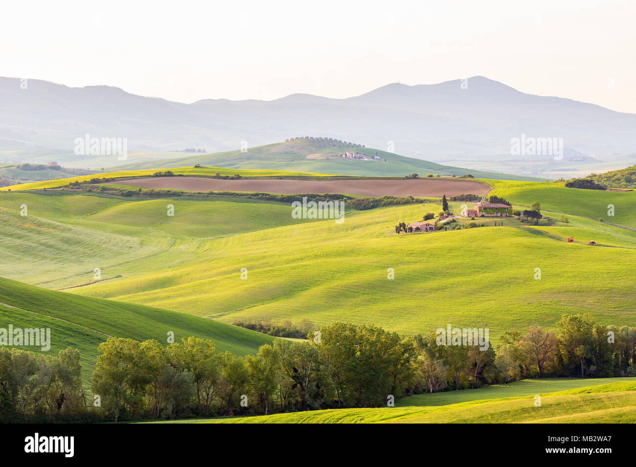 Rolling landscape with a farm on a hill Stock Photo - Alamy