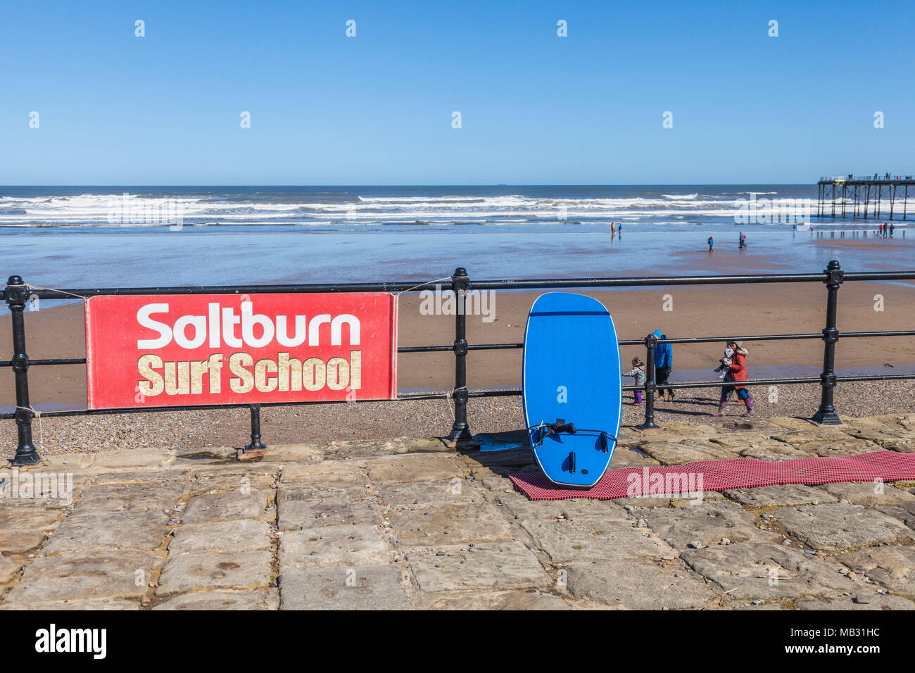 Surf board laid against seafront railings and sign at Saltburn by the ...