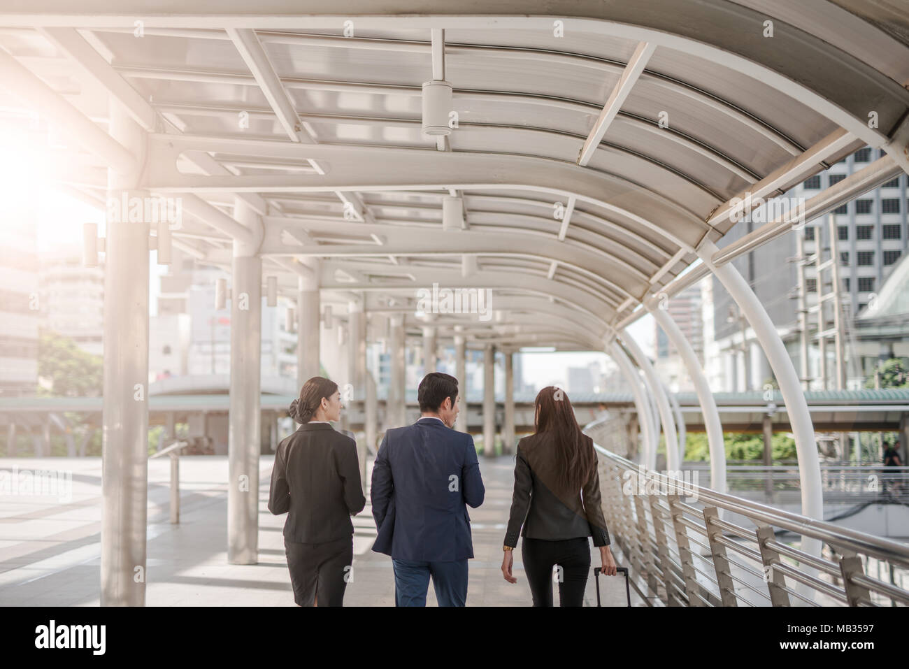 Happy Business colleagues walking outside office & talking to each ...