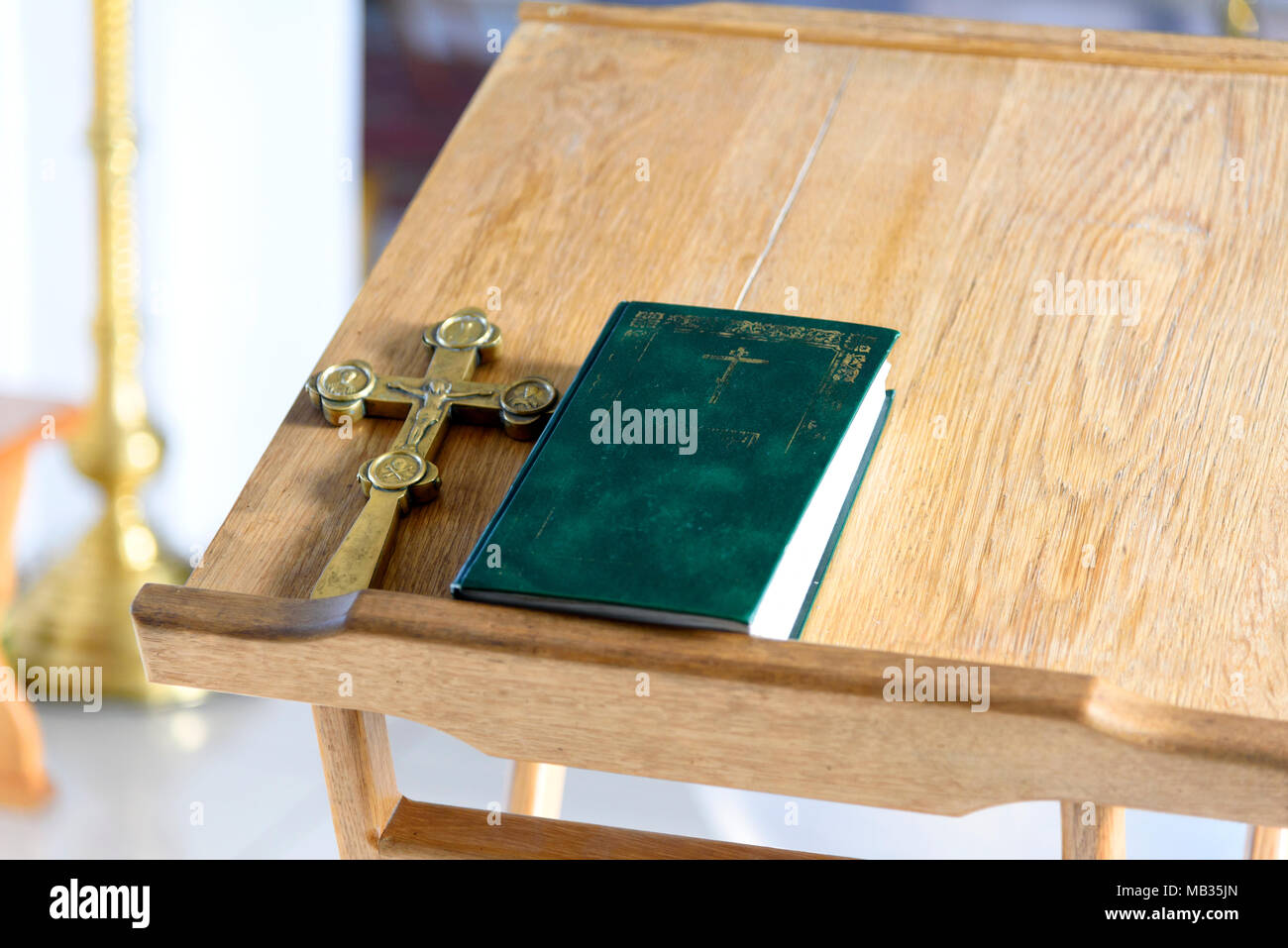 Golden cross crucifix with bible on wooden table. Christian church ...