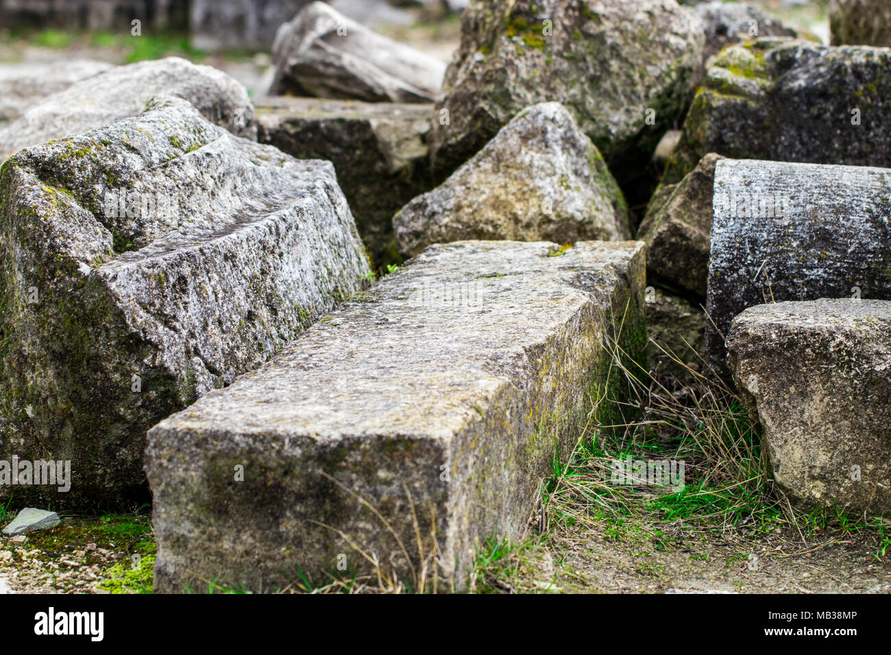 a bunch of ancient stone blocks lying on the grass Stock Photo - Alamy
