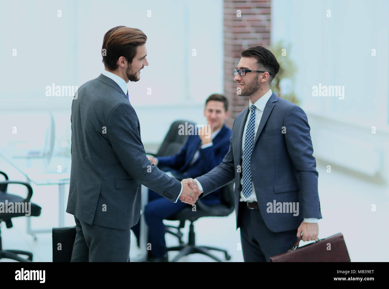 Two businessmen handshaking after striking grand deal Stock Photo - Alamy